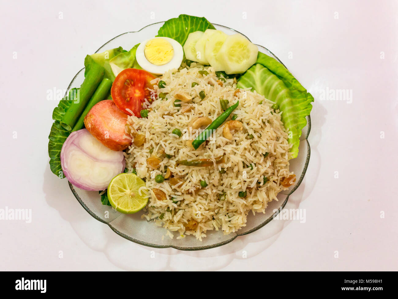 Indian food meal of fried pulao rice with sliced eggs and green ...