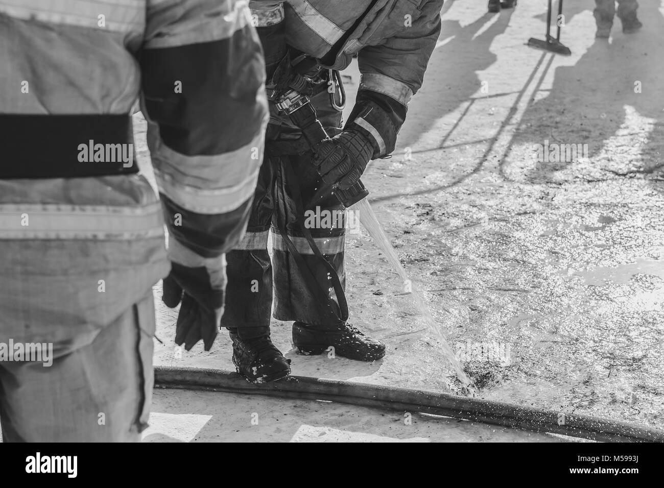 firefighter extinguishes with water Stock Photo - Alamy