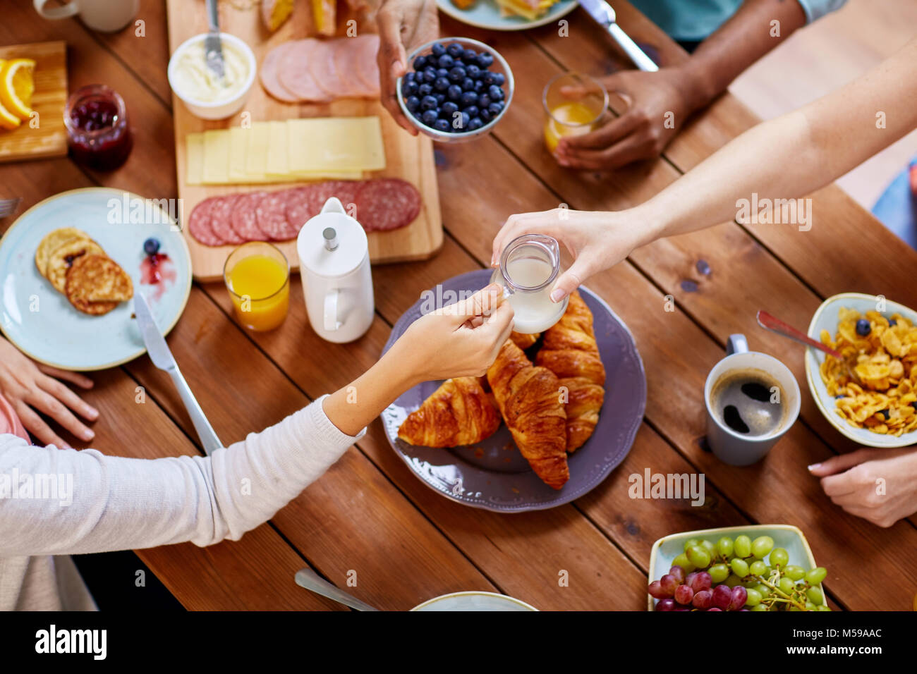 people having breakfast at table with food Stock Photo - Alamy