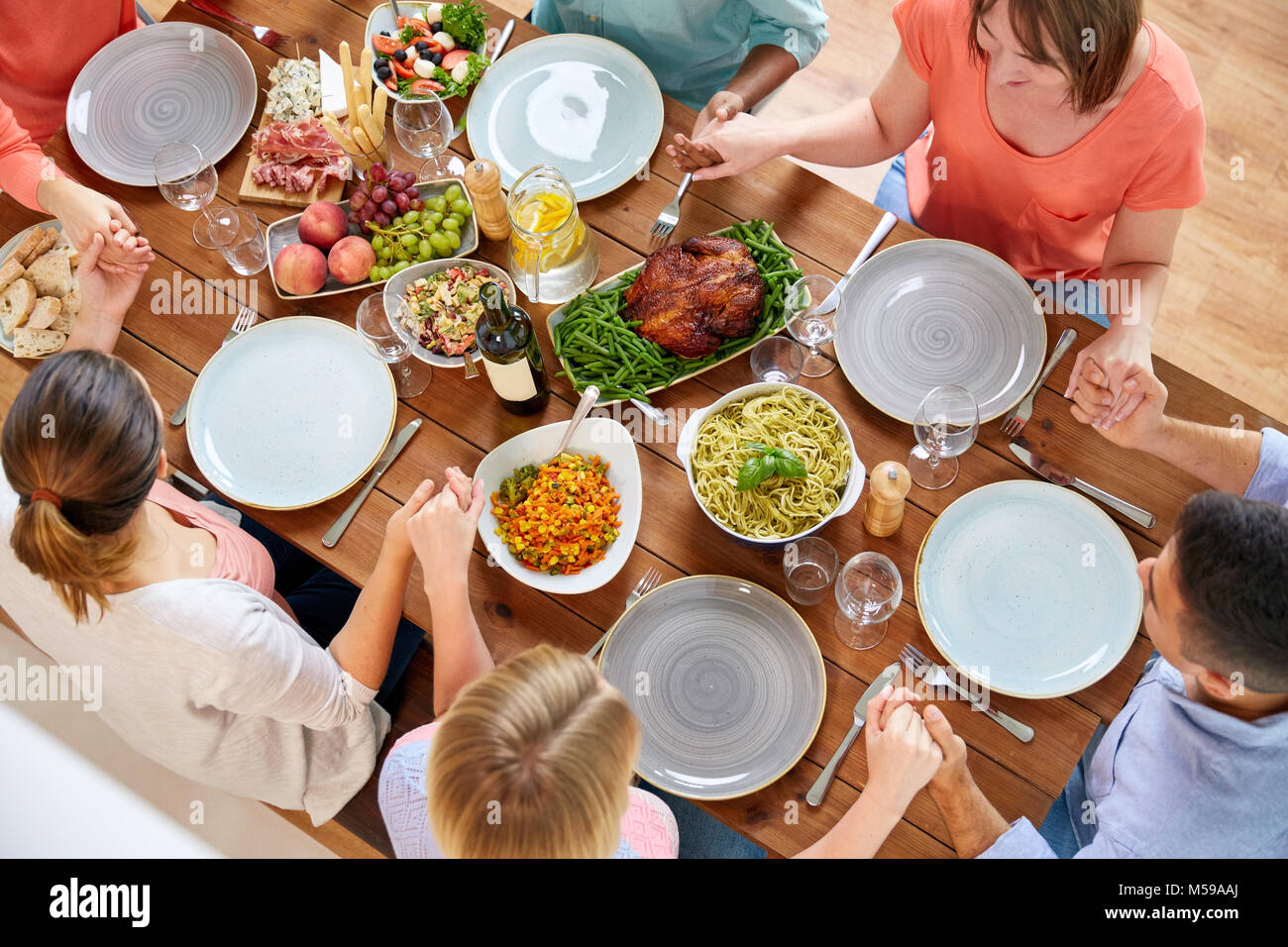 group of people at table praying before meal Stock Photo - Alamy