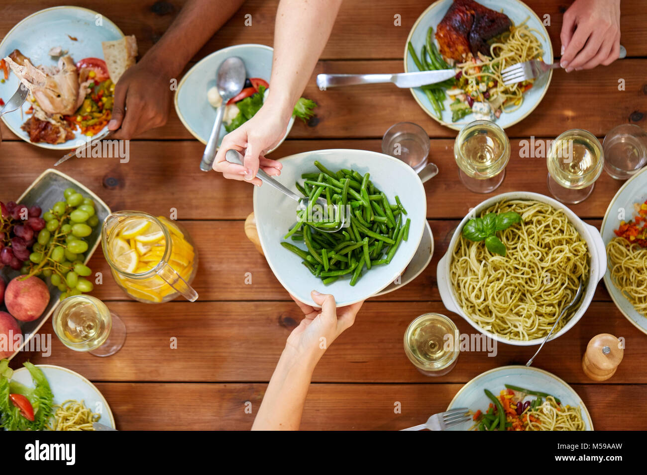 people at table with food eating green beans Stock Photo - Alamy