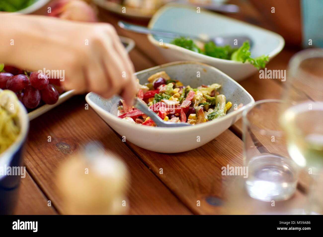 people eating salad at table with food Stock Photo - Alamy