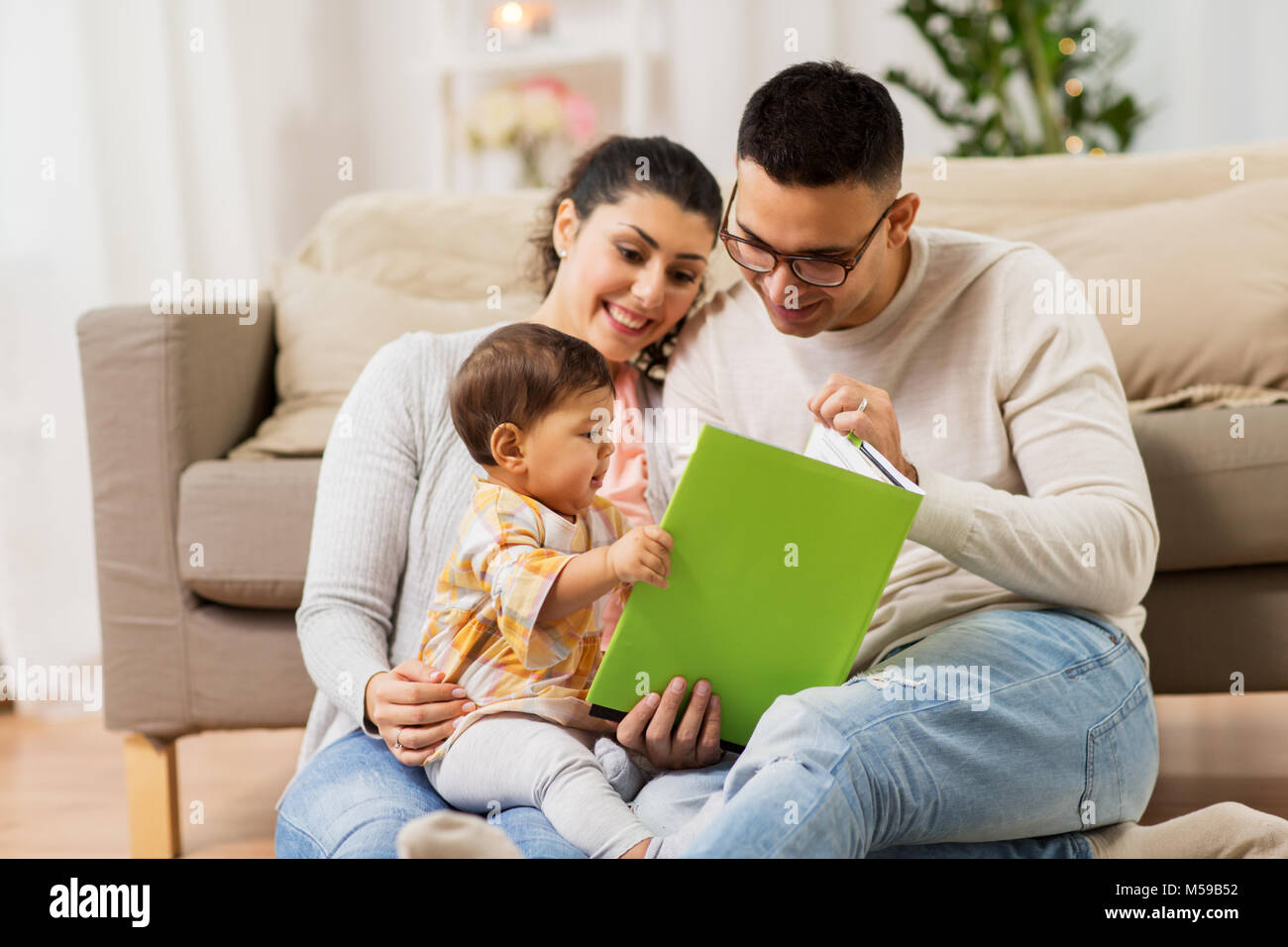 happy family with baby reading book at home Stock Photo - Alamy