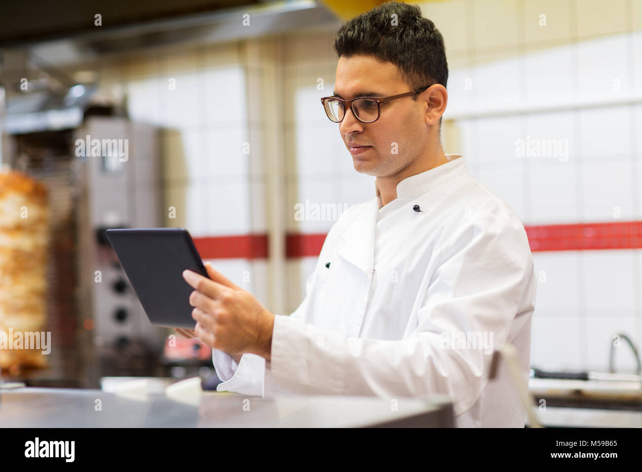 chef cook with tablet pc at restaurant kitchen Stock Photo - Alamy