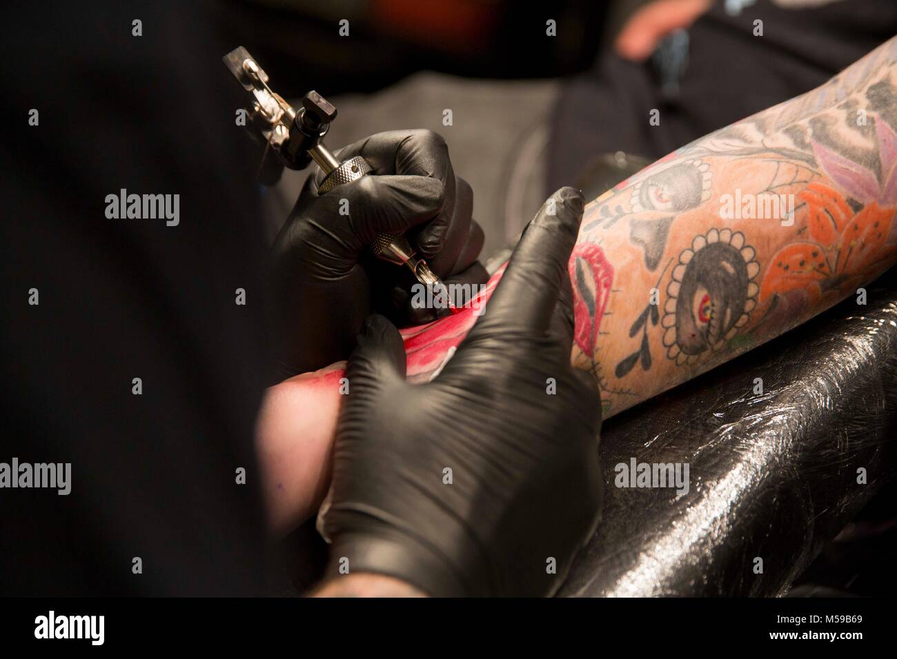 A tattooist works on a customer's forearm Stock Photo - Alamy