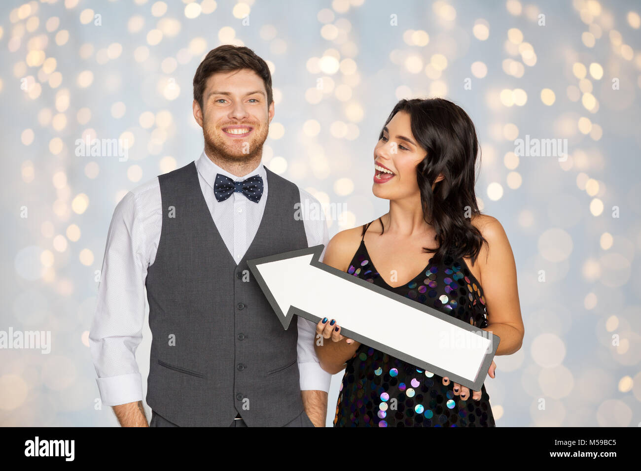 happy couple with big arrow at party Stock Photo - Alamy