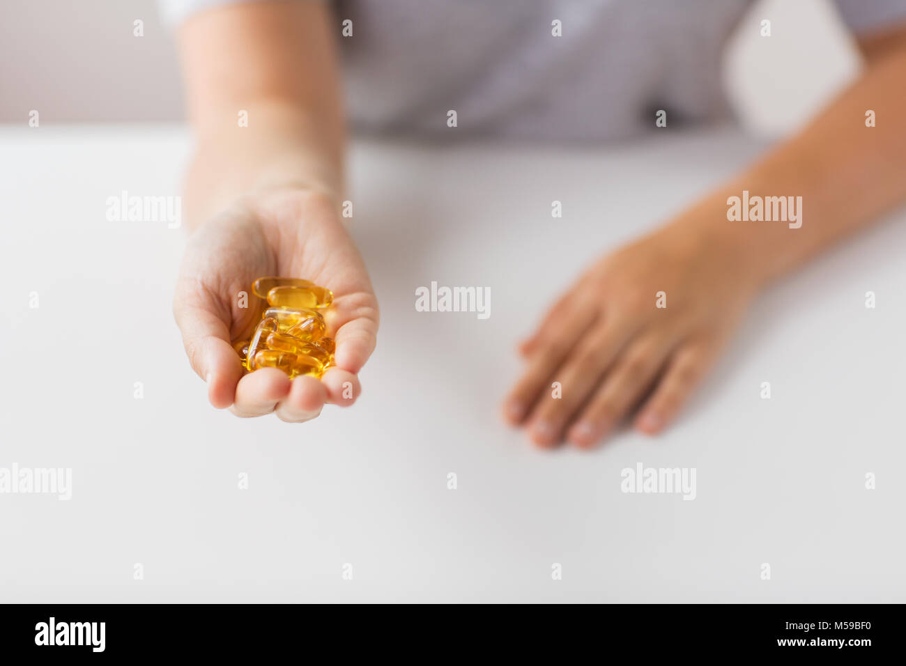 Cod liver oil capsules hand hi-res stock photography and images - Alamy