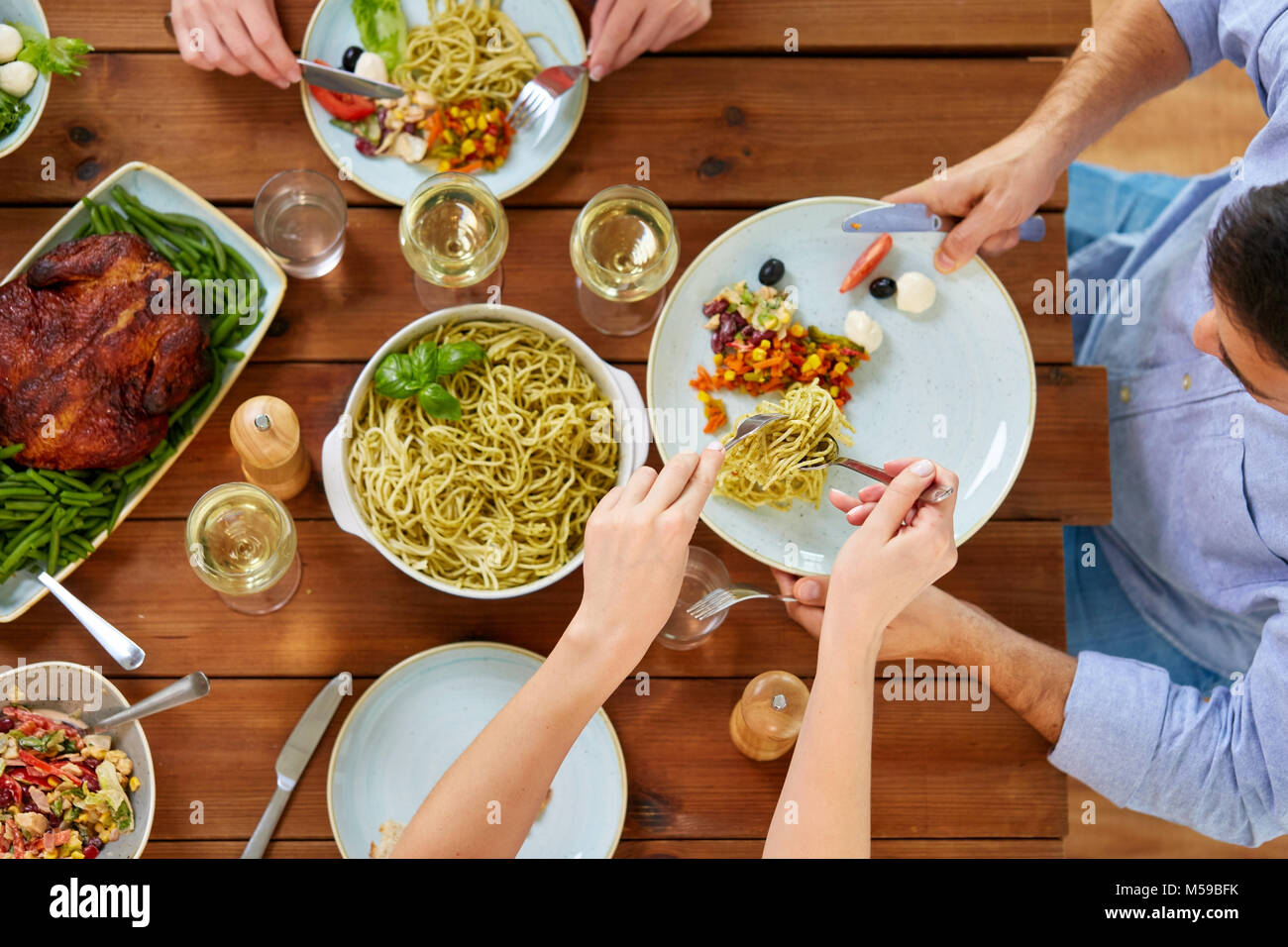 people at table with food eating pasta for dinner Stock Photo - Alamy