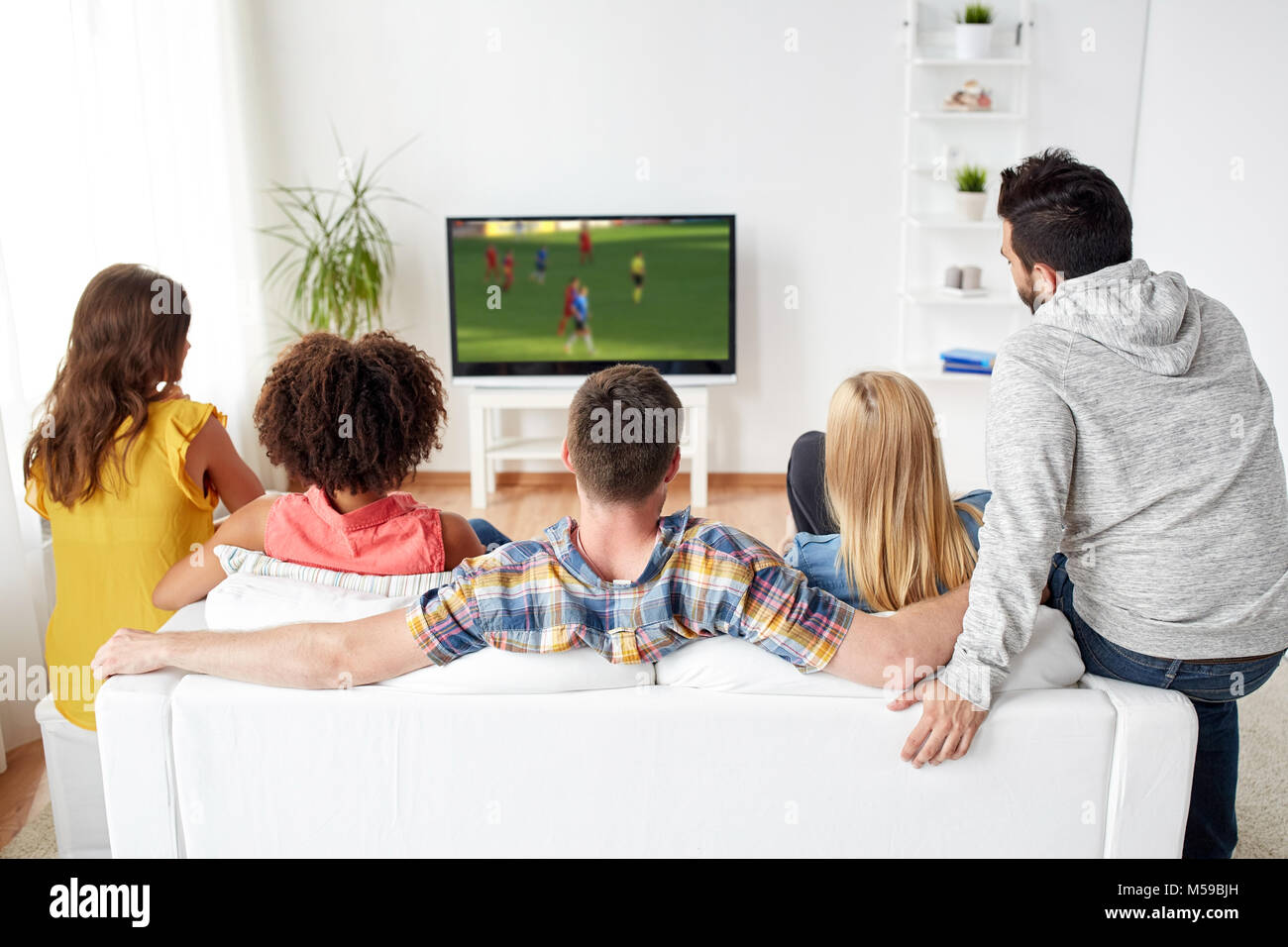 friends watching soccer game on tv at home Stock Photo - Alamy