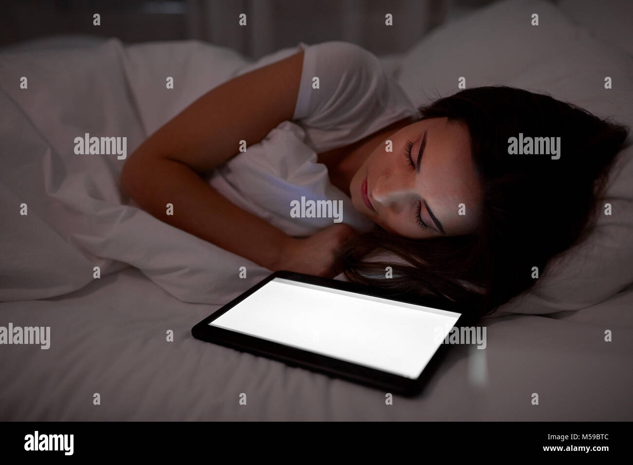 woman with tablet pc sleeping in bed at night Stock Photo - Alamy