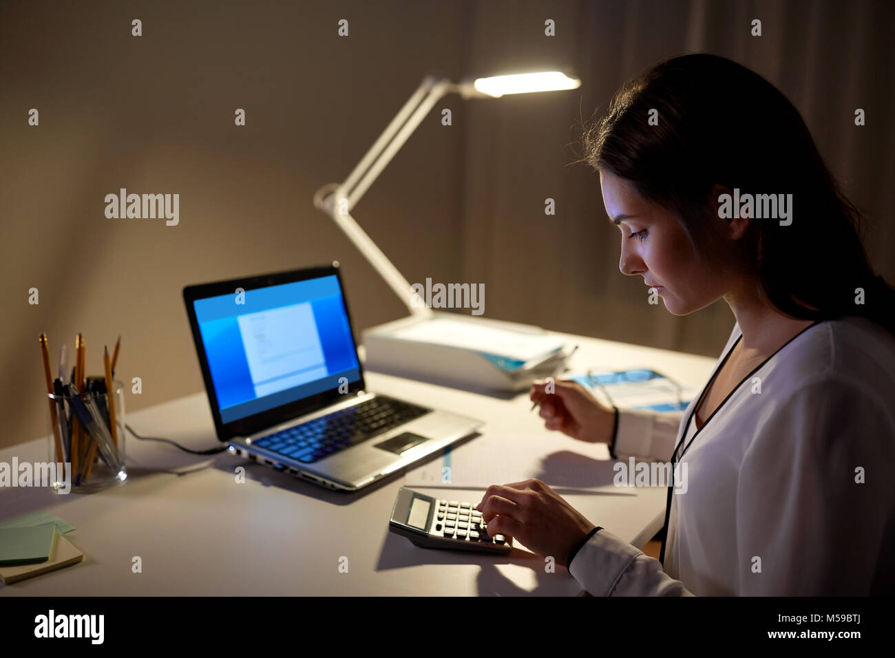 Woman calculating invoice calculator hi-res stock photography and ...