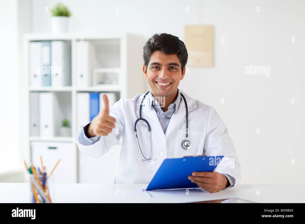 happy doctor at clinic showing thumbs up Stock Photo - Alamy