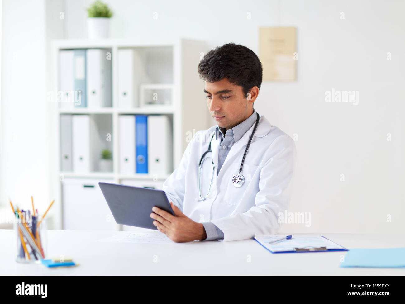 doctor with tablet pc and stethoscope at clinic Stock Photo - Alamy