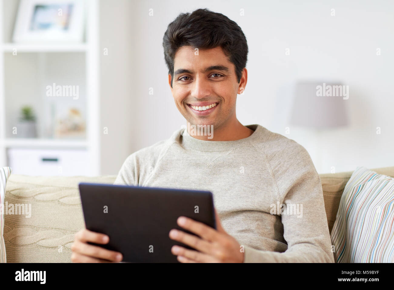 smiling man with tablet pc at home Stock Photo - Alamy