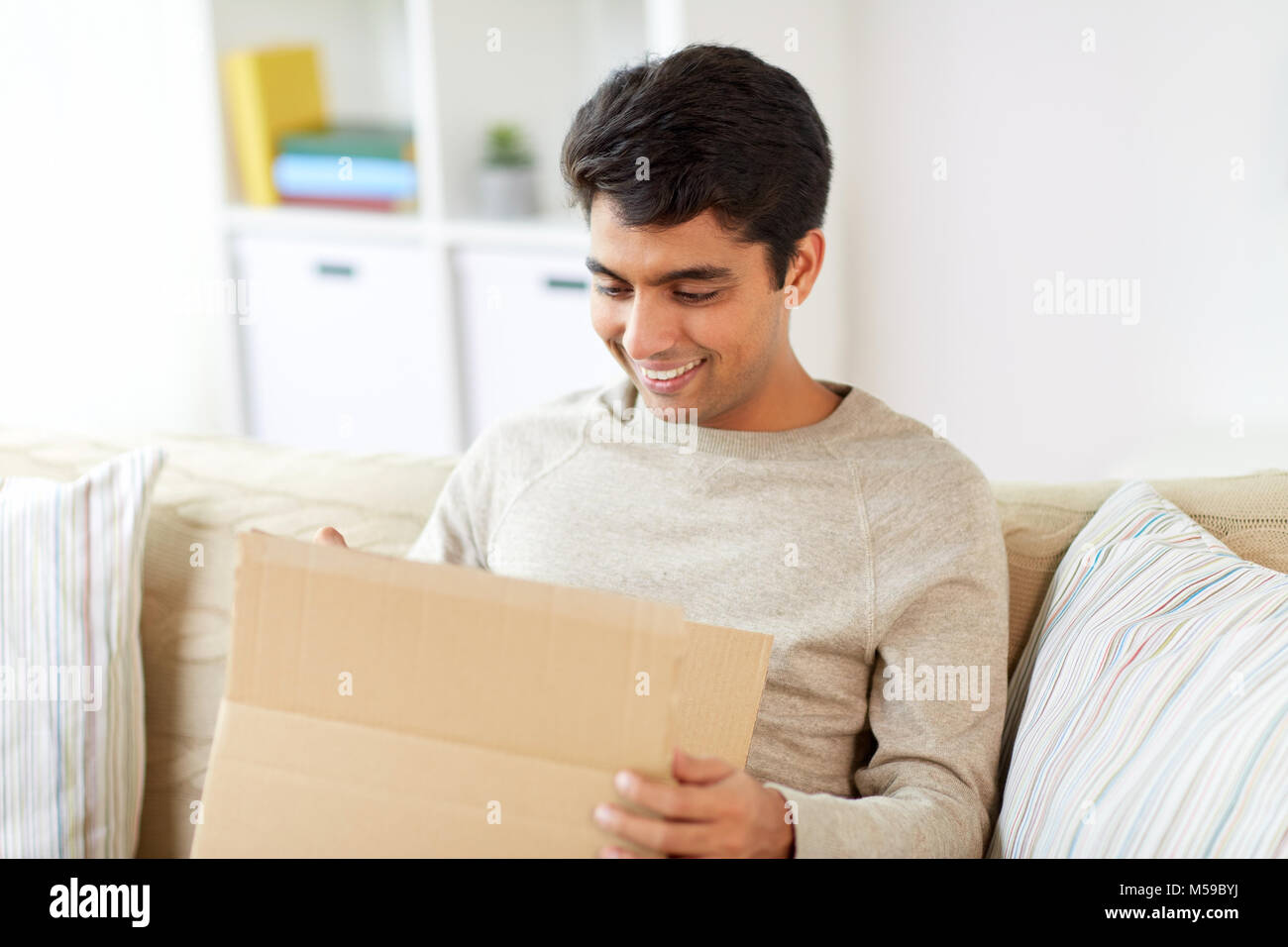 happy man opening parcel box at home Stock Photo - Alamy