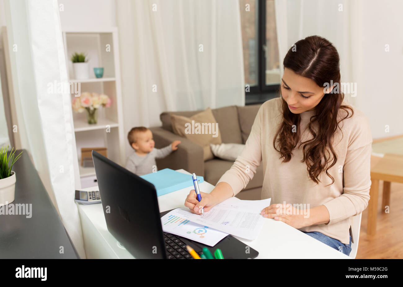 happy mother with baby and papers working at home Stock Photo - Alamy