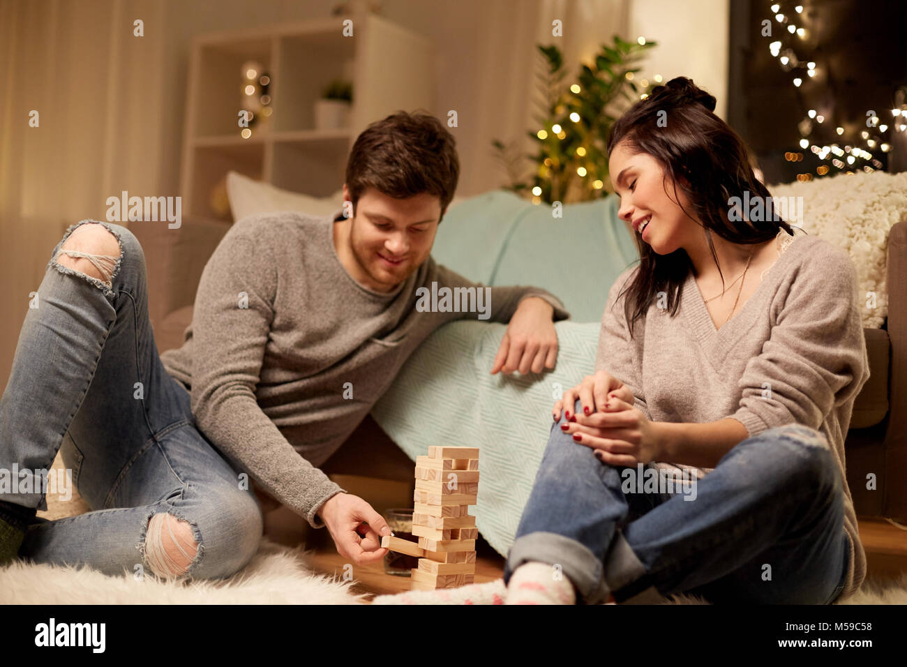 happy couple playing block-stacking game at home Stock Photo - Alamy