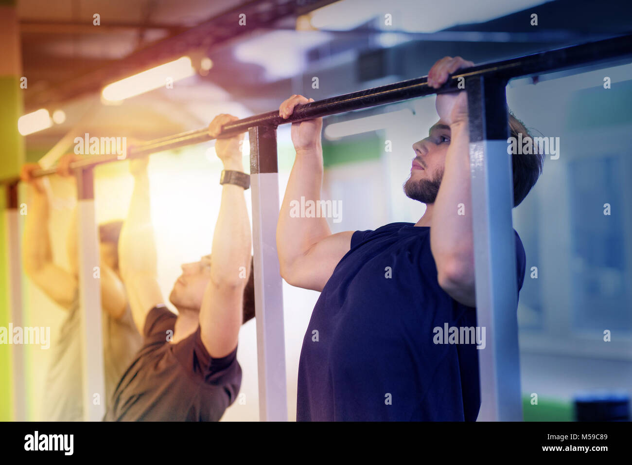 group of young men doing pull-ups in gym Stock Photo - Alamy