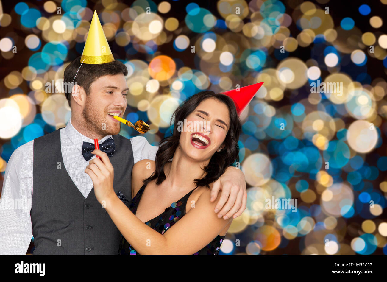 happy couple with party blowers having fun Stock Photo - Alamy