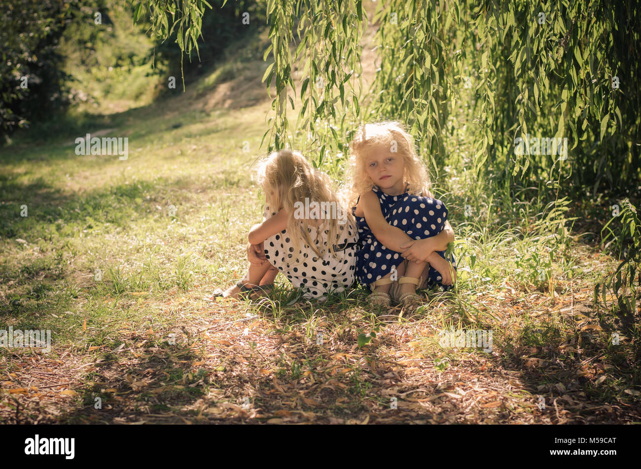 Two girls under tree hi-res stock photography and images - Alamy
