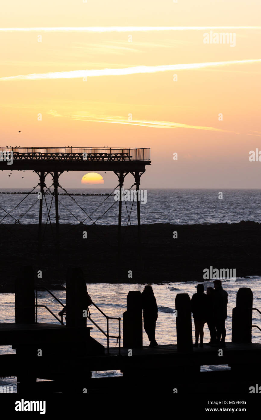 silhouetted People watching the sun go down at sunset Stock Photo - Alamy