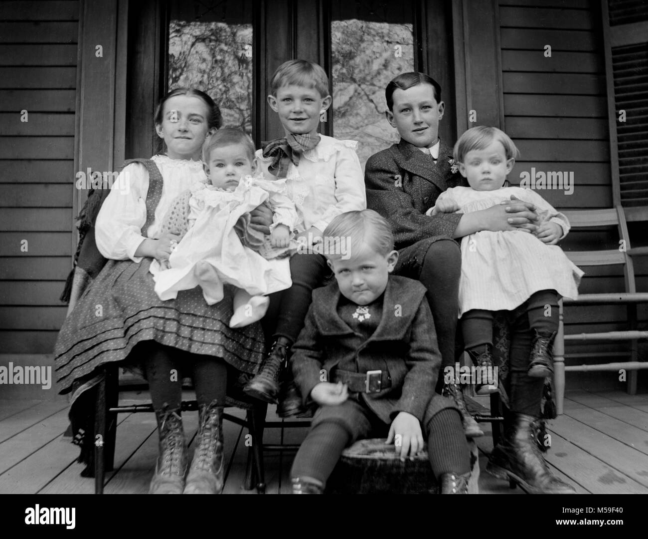 The children gather for a formal portrait on the front porch, ca. 1900 ...
