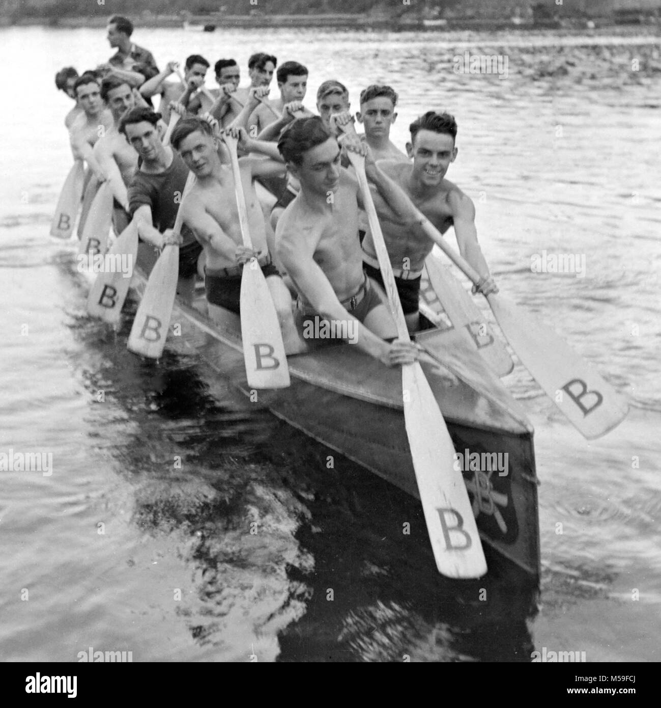 A shirtless group of fit young men row during a race in Nova Scotia, ca ...