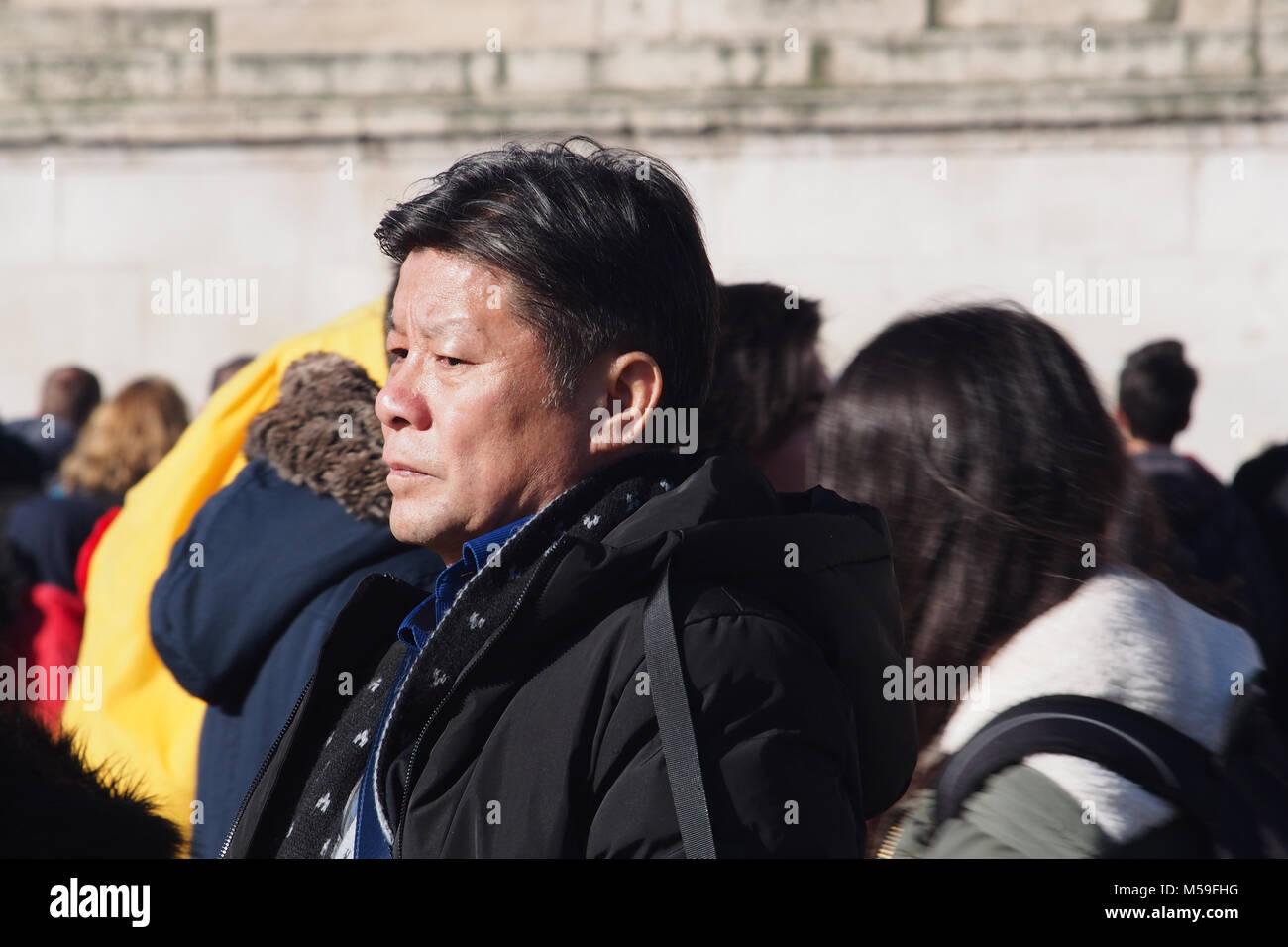 Man Standing Alone In Crowd