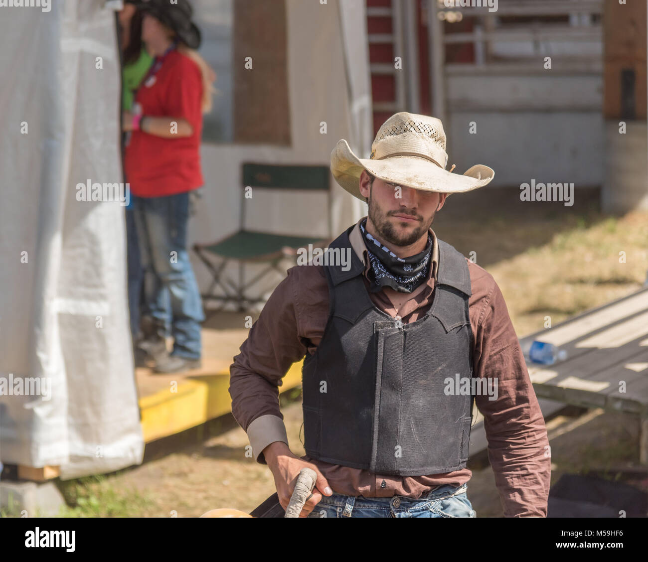 Cowboy walks toward arena to compete in the Wild Horse Race at the 90th ...