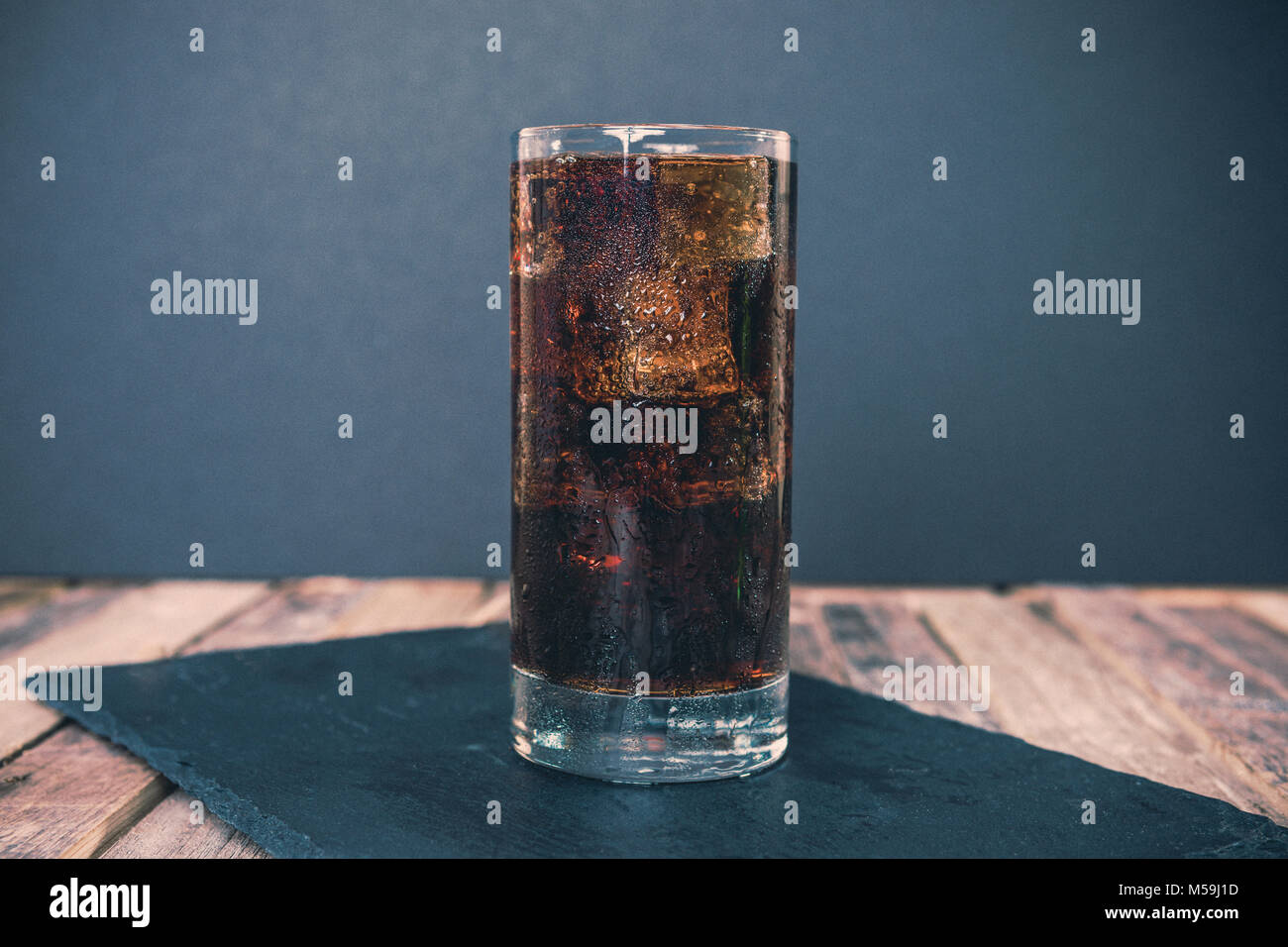 Glass of ice cold cola on dark background Stock Photo - Alamy