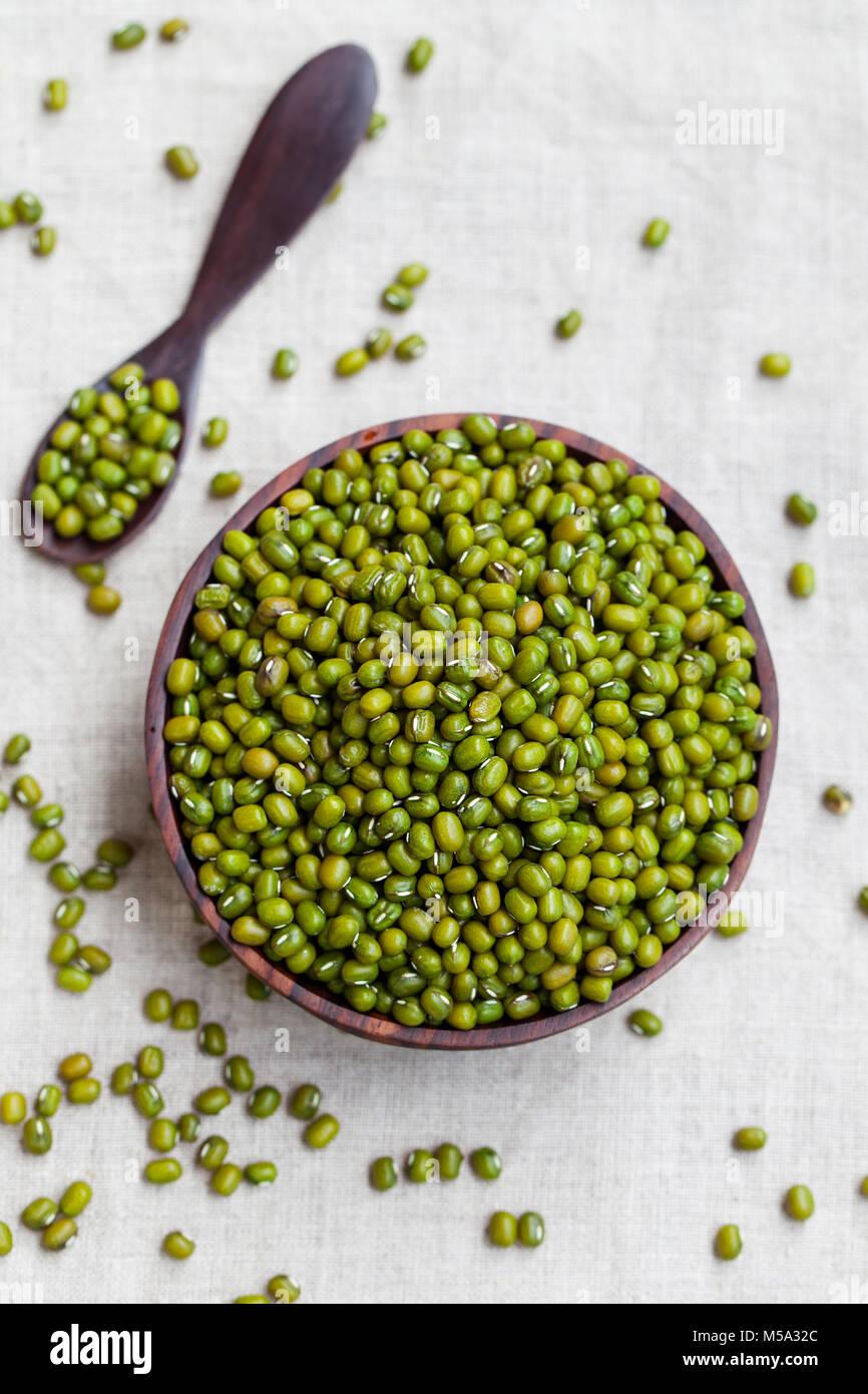 Mung bean, green moong dal in wooden bowl. White textile background ...