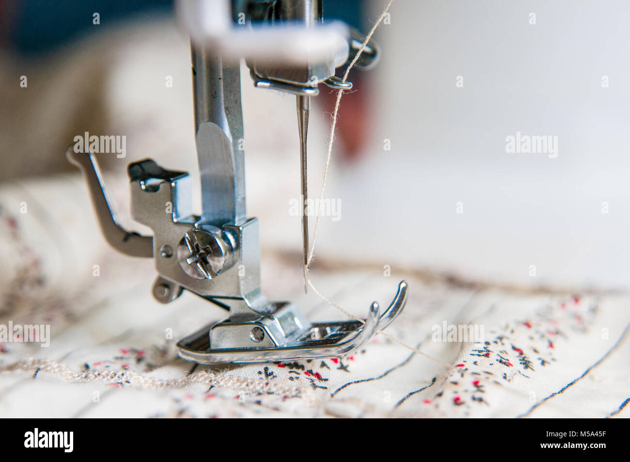 Modern Sewing machine with light flower pattern fabric Stock Photo - Alamy