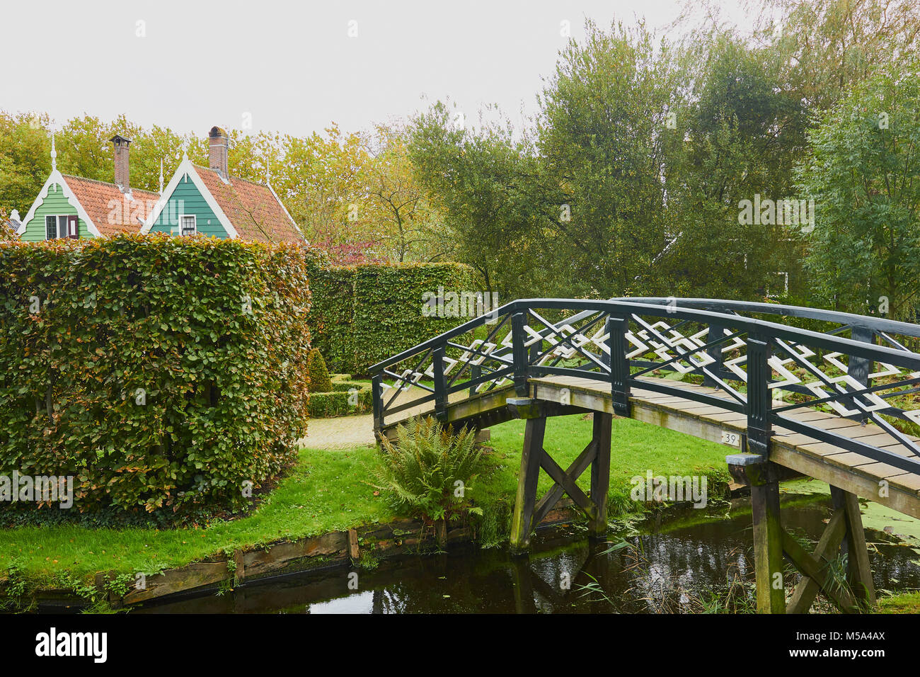Rural scene with footbridge and traditional Dutch houses, Netherlands ...