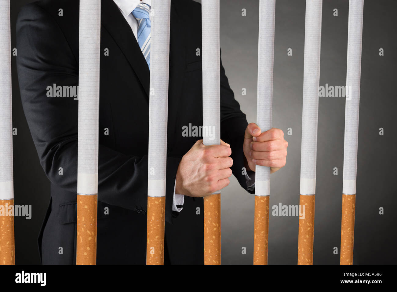 Midsection of businessman holding big cigarettes while wearing ...