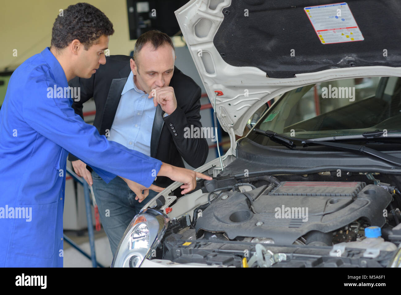 mechanic helping trainee to fix engine Stock Photo - Alamy