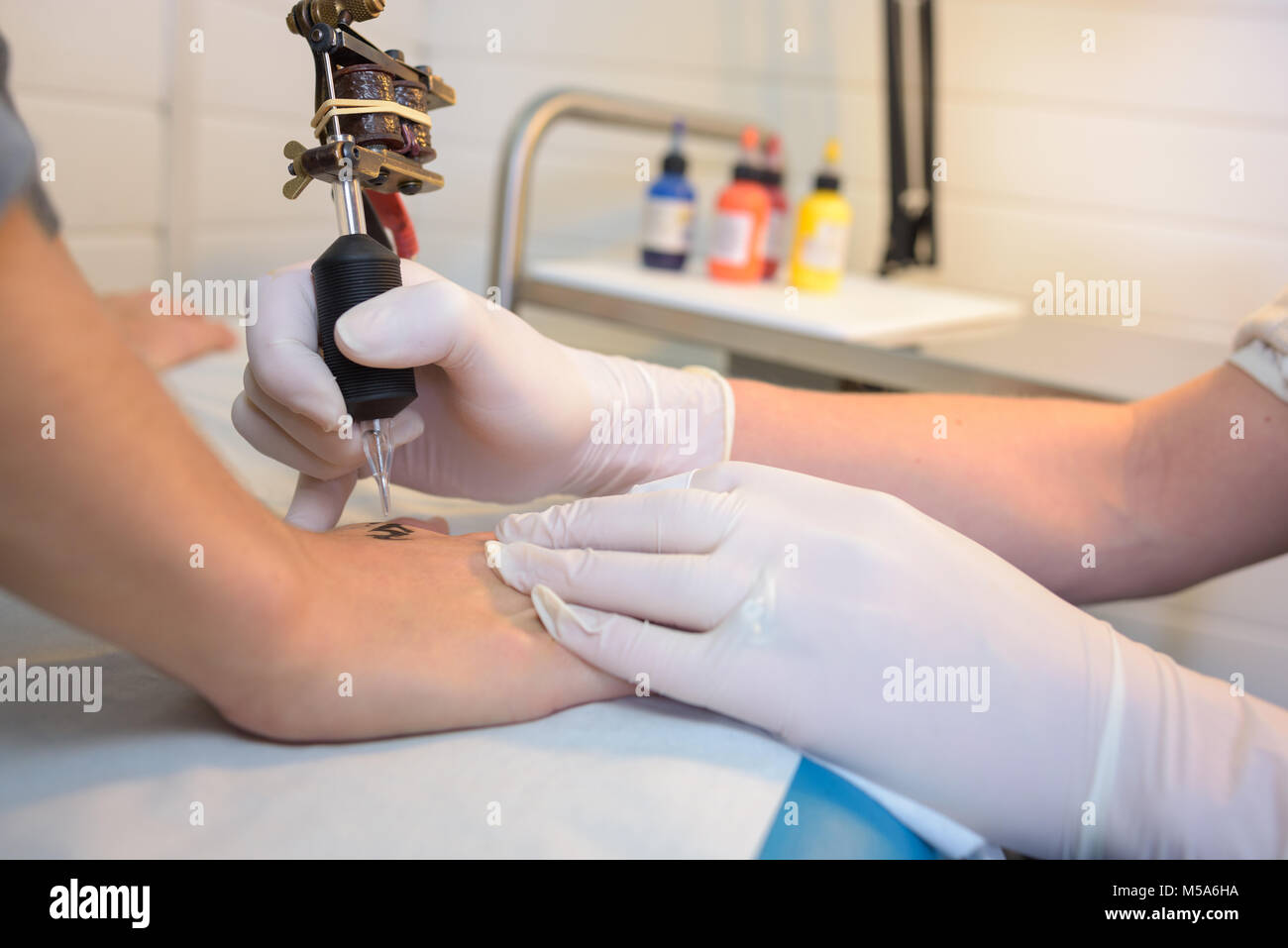 Woman having tattoo on arm Stock Photo - Alamy