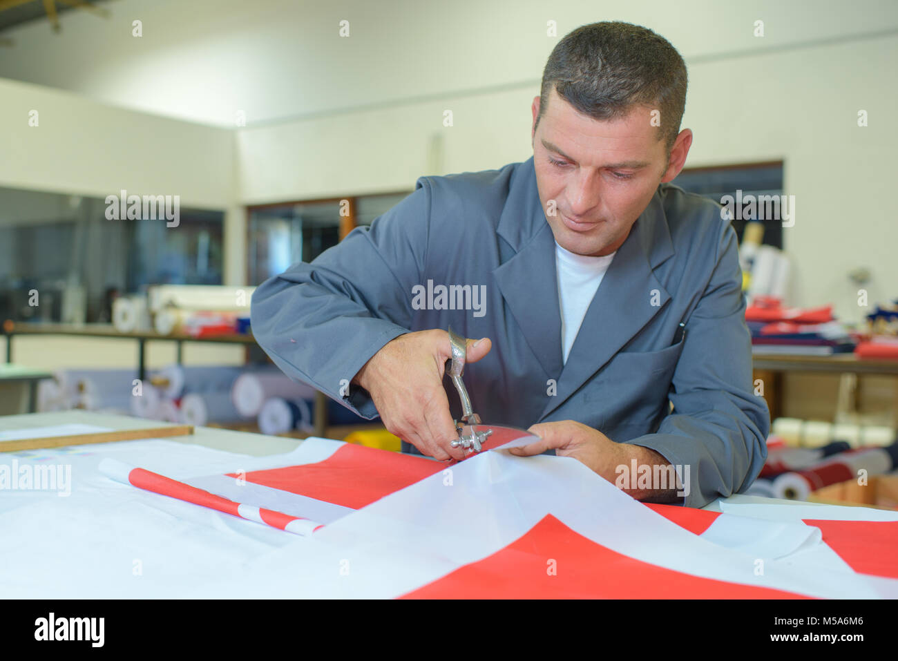 Man cutting fabric Stock Photo - Alamy
