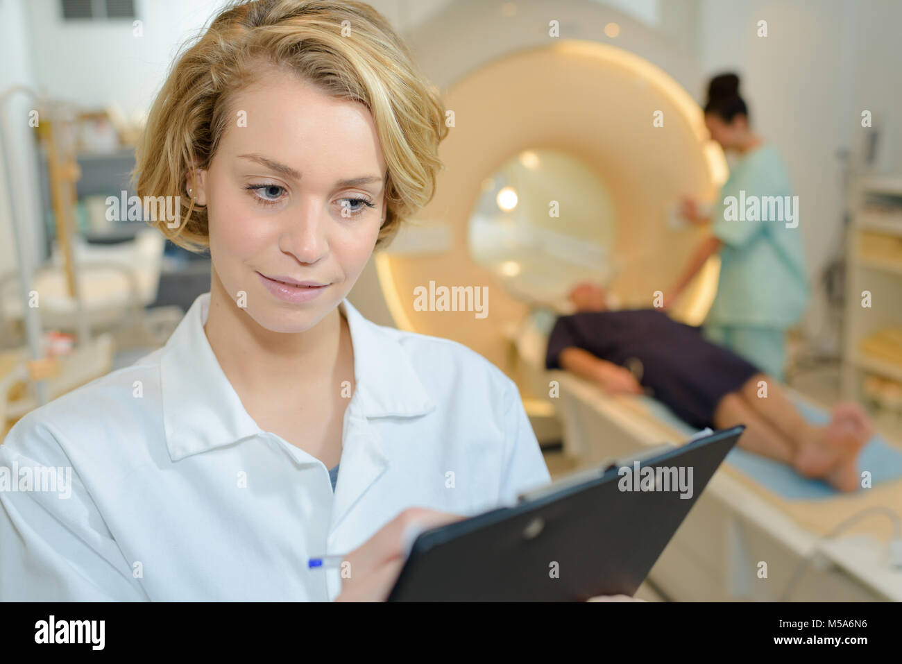 doctor writing the patients mri record Stock Photo - Alamy