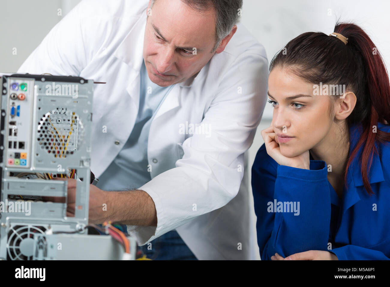 tutor assisting woman setting up computer Stock Photo - Alamy