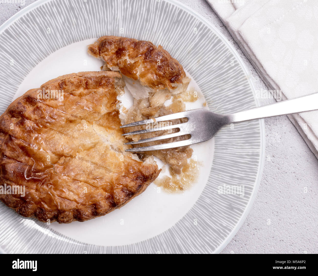 Overhead View of a Chicken pie on a plate with fork and napkin Stock ...