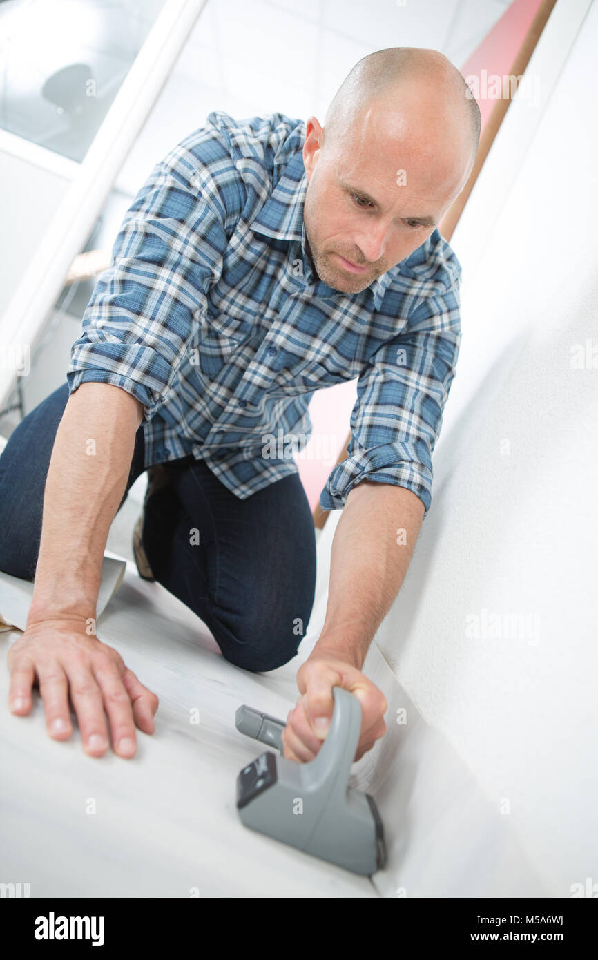 male craftsman fitting carpet on floor Stock Photo - Alamy