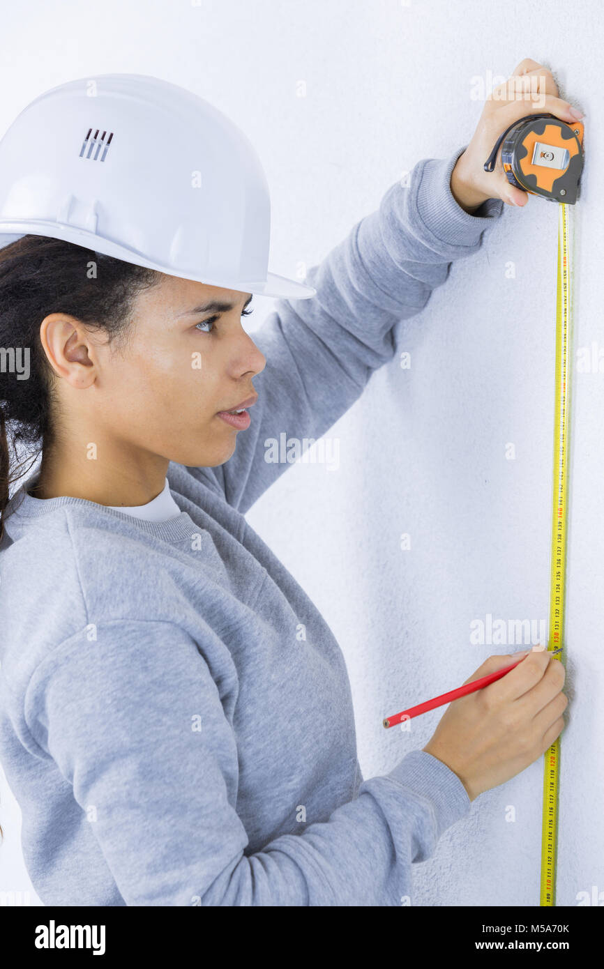 Woman measuring wall and marking position with pencil Stock Photo - Alamy