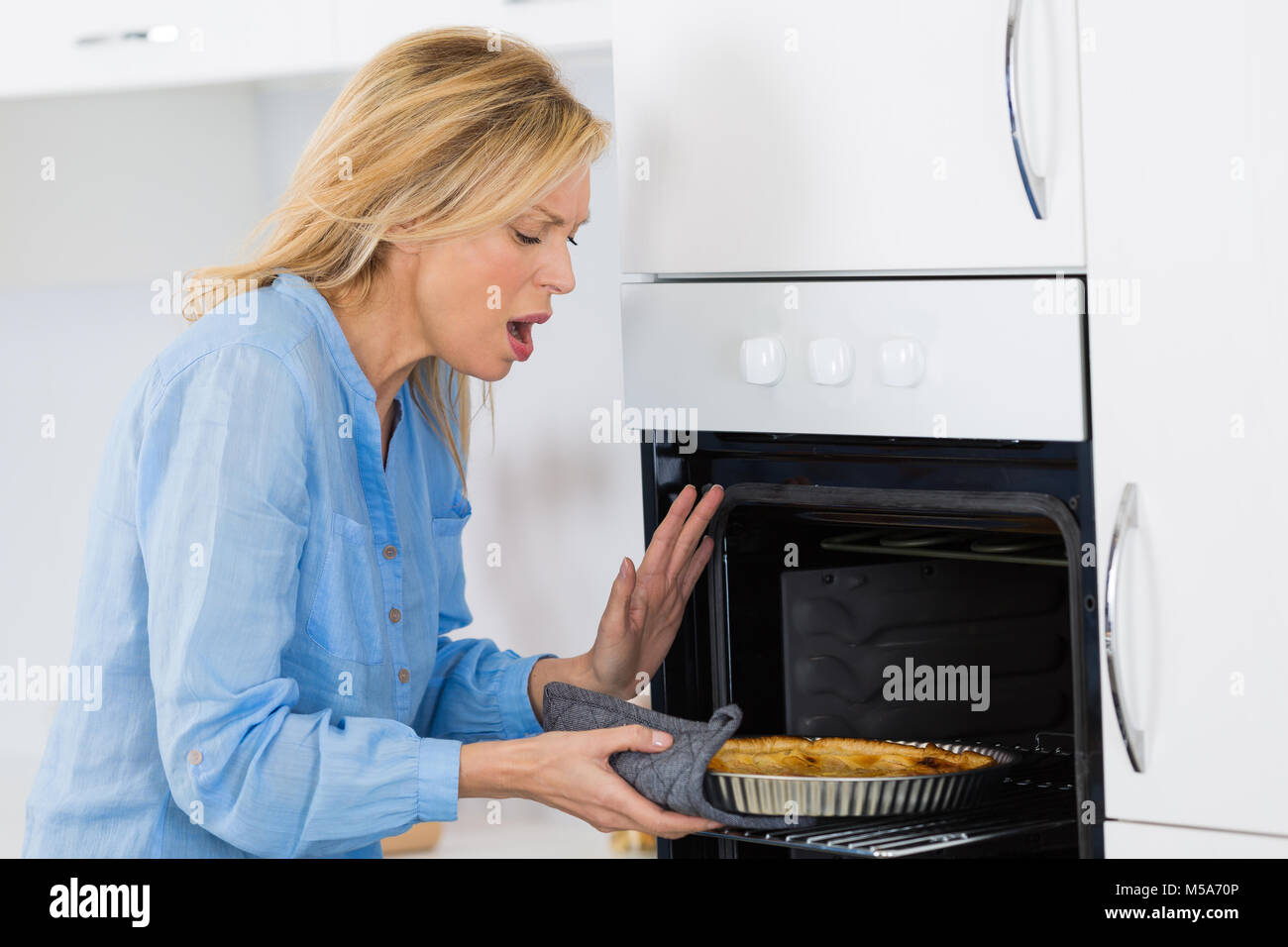 woman burn hand while getting a tart off the oven Stock Photo - Alamy