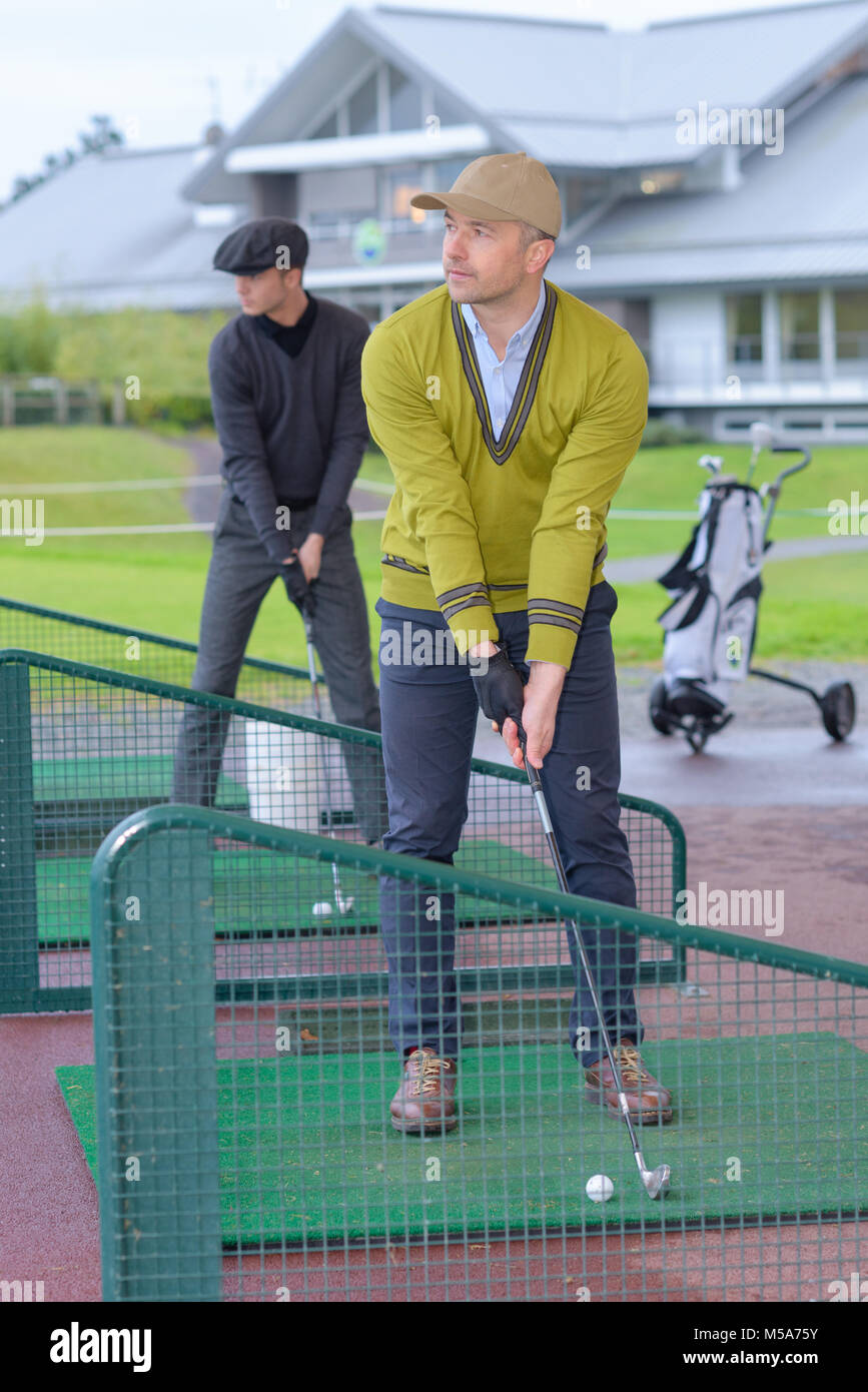 men practicing golfing technique on platform Stock Photo - Alamy