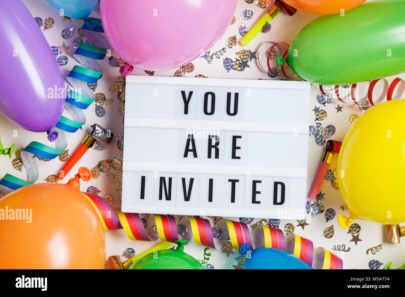 Party celebration background with you are invited message on a lightbox ...