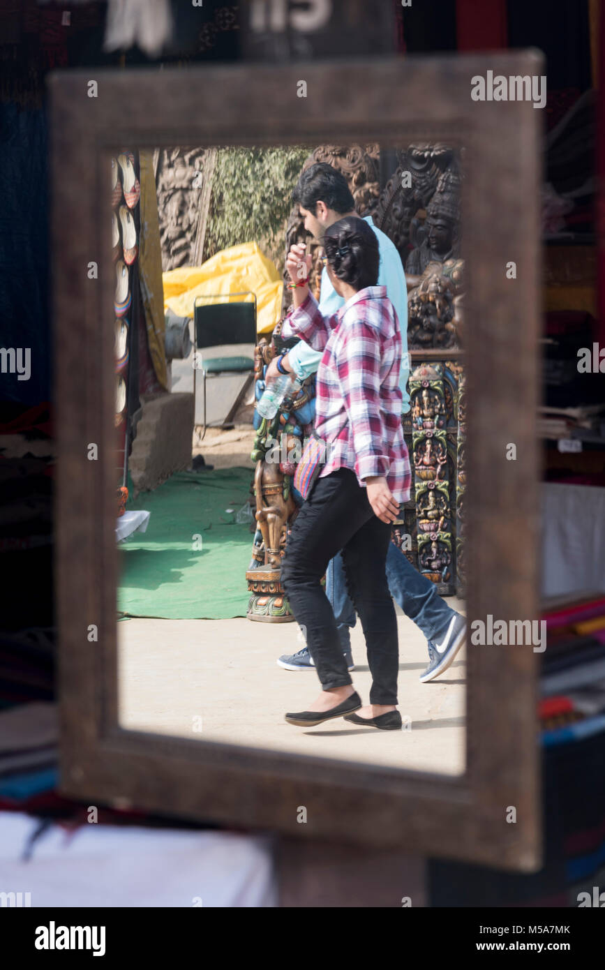 Two people walking in front of a mirror Stock Photo - Alamy
