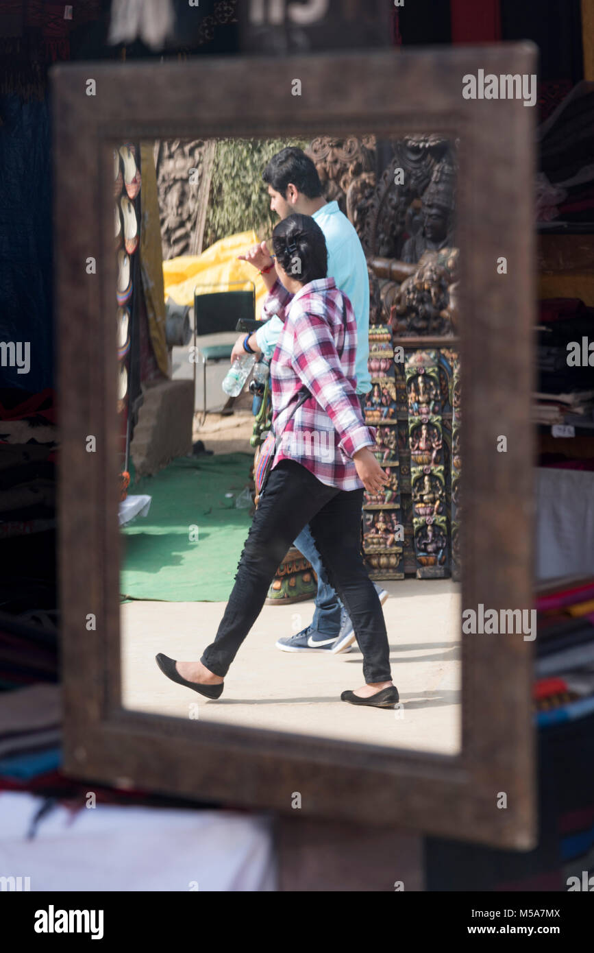 Two people walking in front of a mirror Stock Photo - Alamy