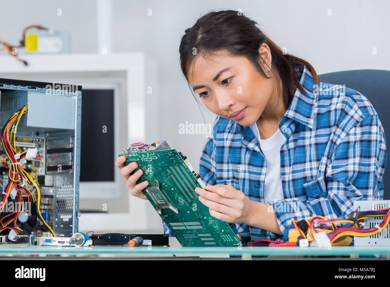 young adult female working on assembling circuit components Stock Photo ...