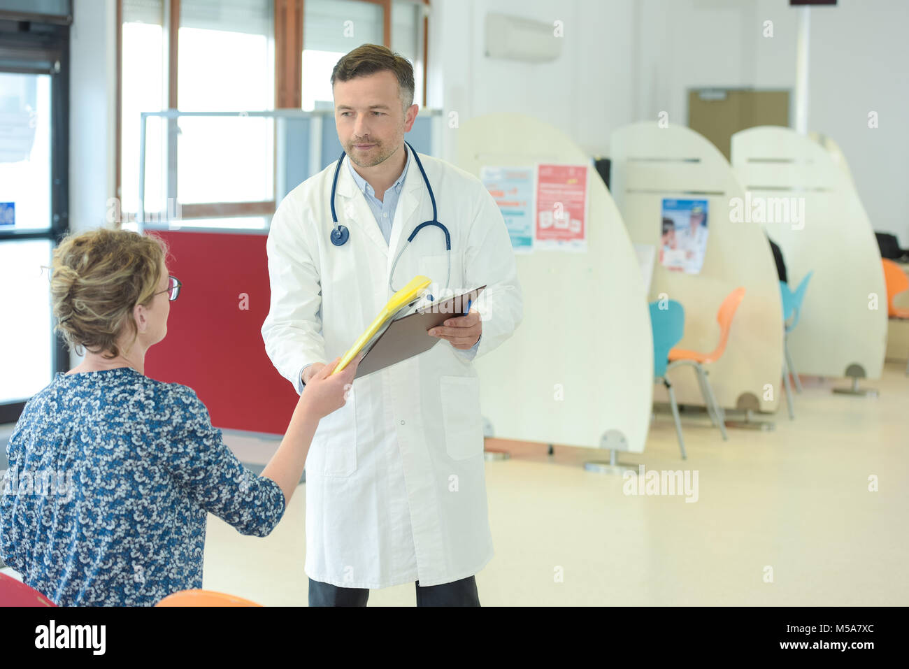 doctor talking to a patient in the lobby Stock Photo - Alamy