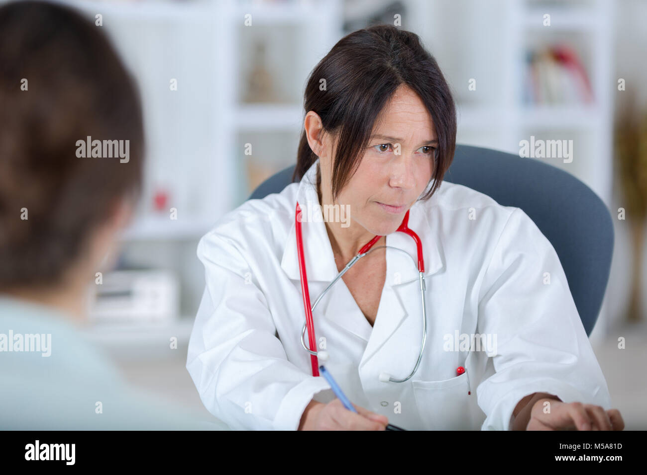 portrait of a beautiful female doctor working in her office Stock Photo ...